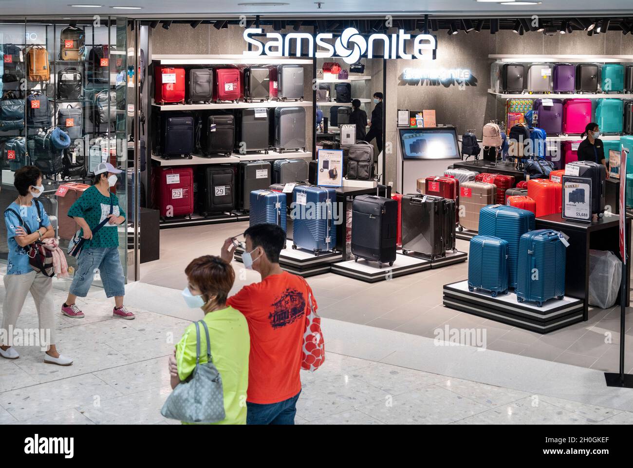 Shoppers walk past the American luggage manufacturer and retailer ...