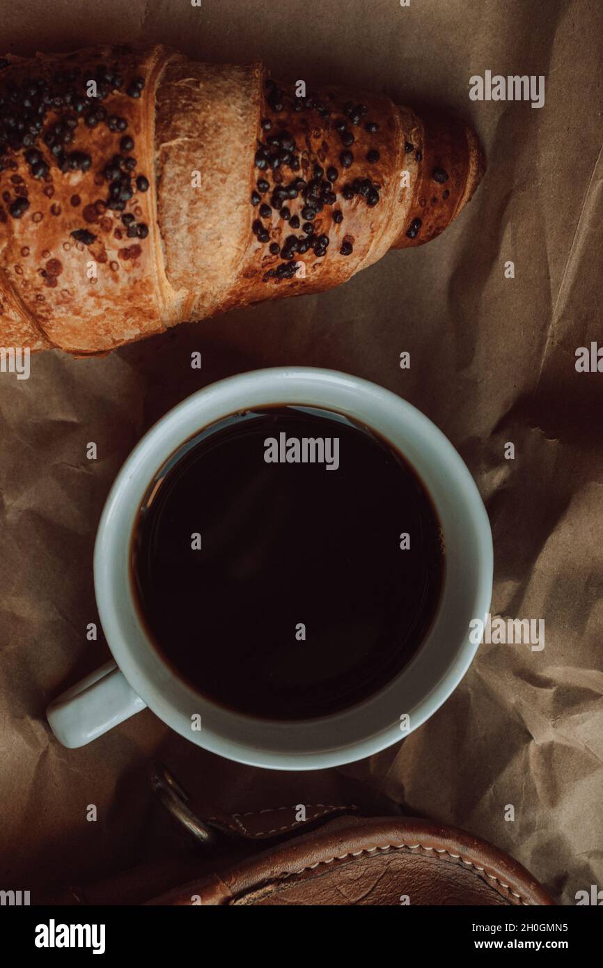 A cup of black morning coffee with a chocolate croissant. Delicious ...
