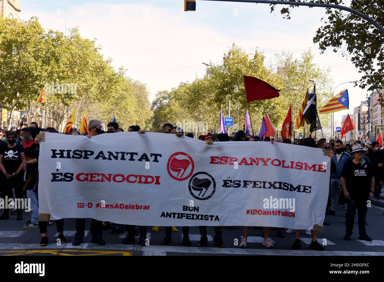 Demonstrators march with a huge banner with the slogan "Hispanic is ...