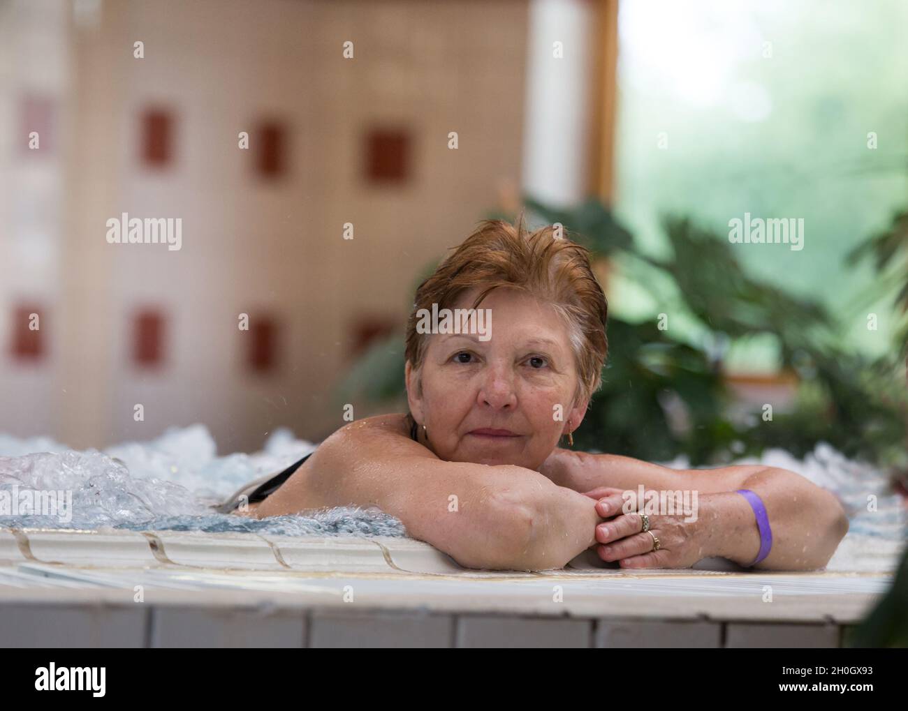 Elderly woman enjoying in pool with hot water in spa resort Stock Photo ...