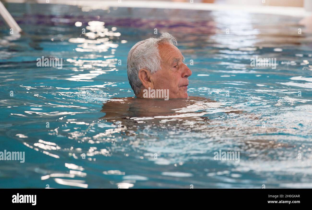 Elderly man swimming and enjoying in pool in spa resort Stock Photo - Alamy