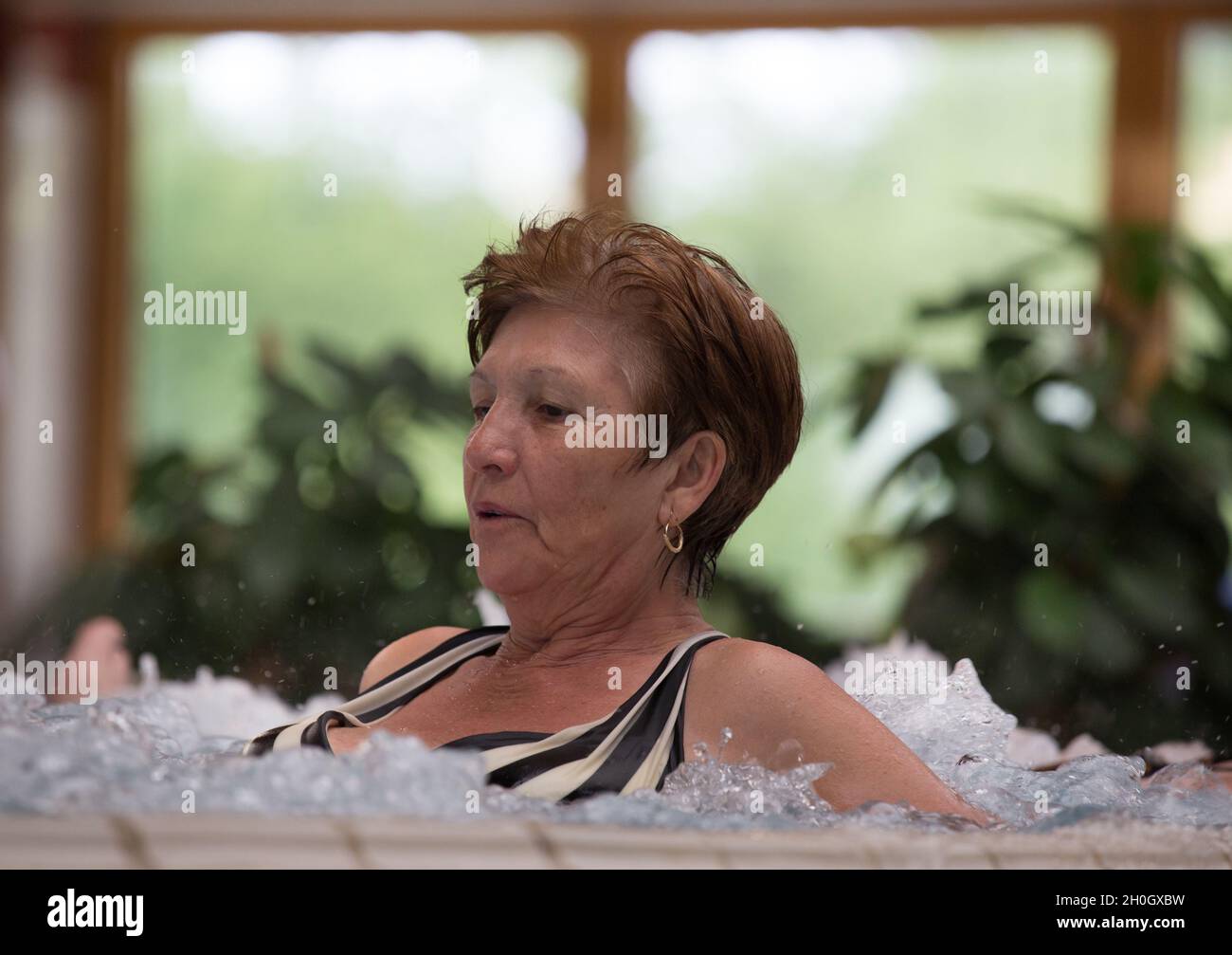 Elderly woman enjoying in pool with hot water in spa Stock Photo - Alamy