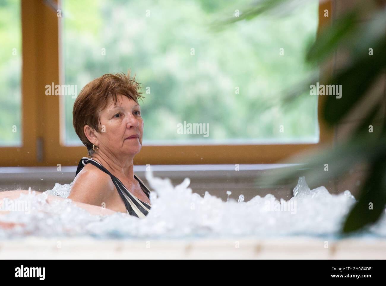 Elderly woman enjoying in pool with hot water in spa resort Stock Photo ...