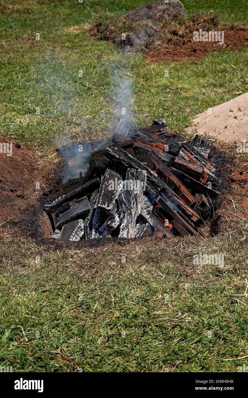 A smoldering fire in which a camp oven is being cooked to provide food ...