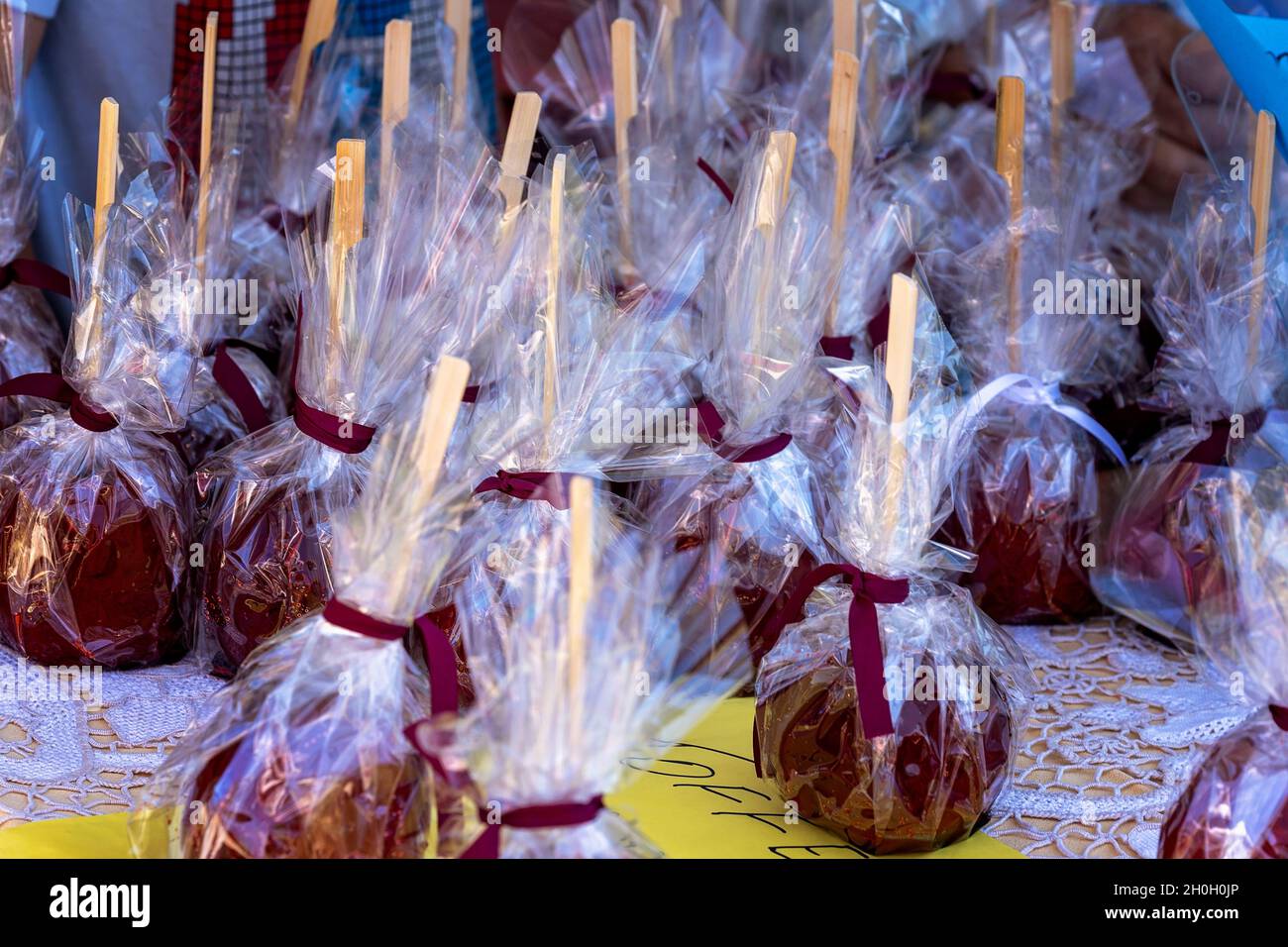Red toffee apples on sticks wrapped in clear cellophane for sale at a ...