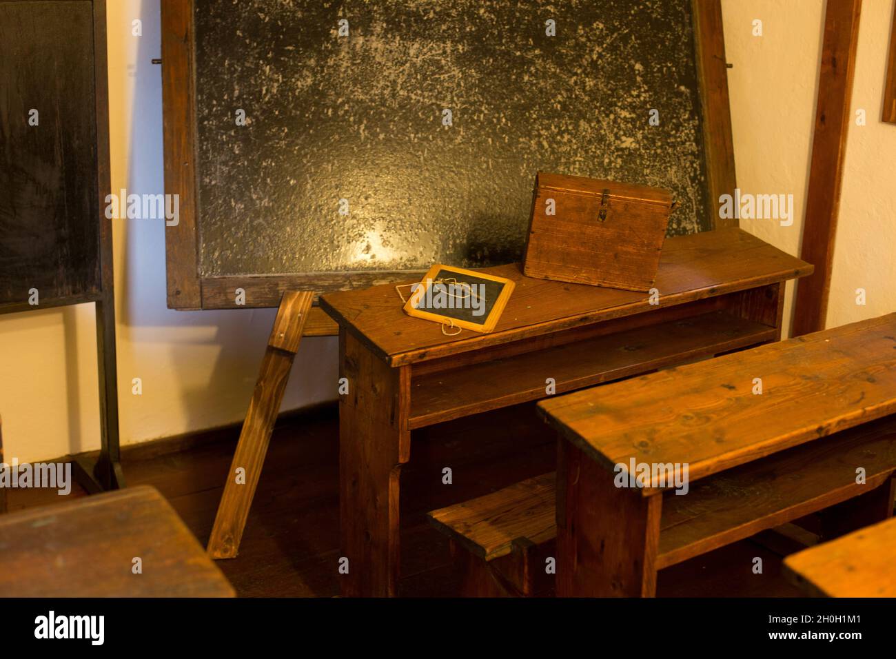 Vintage school classroom with wooden bench and desk and old blackboard ...