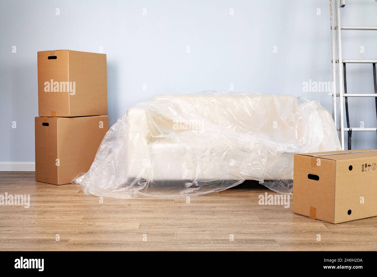 Packed household stuff in boxes and packed sofa for moving Stock Photo ...