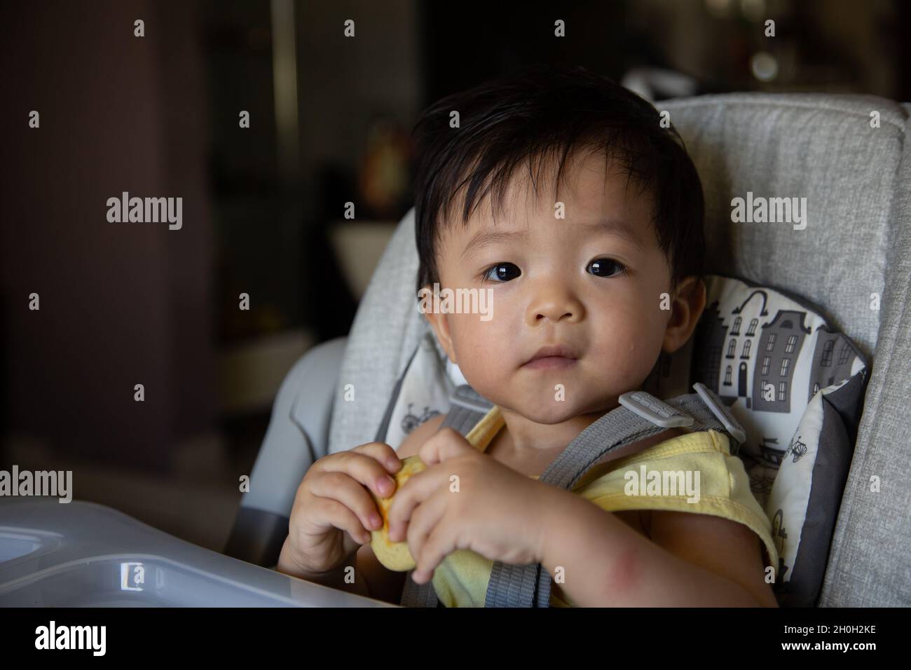 Adorable joyful and Happy 1years old Chinese baby boy having food while ...