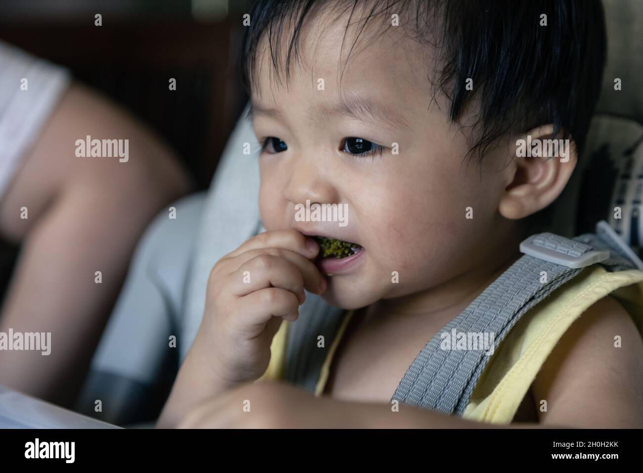 Adorable joyful and Happy 1years old Chinese baby boy having food while ...