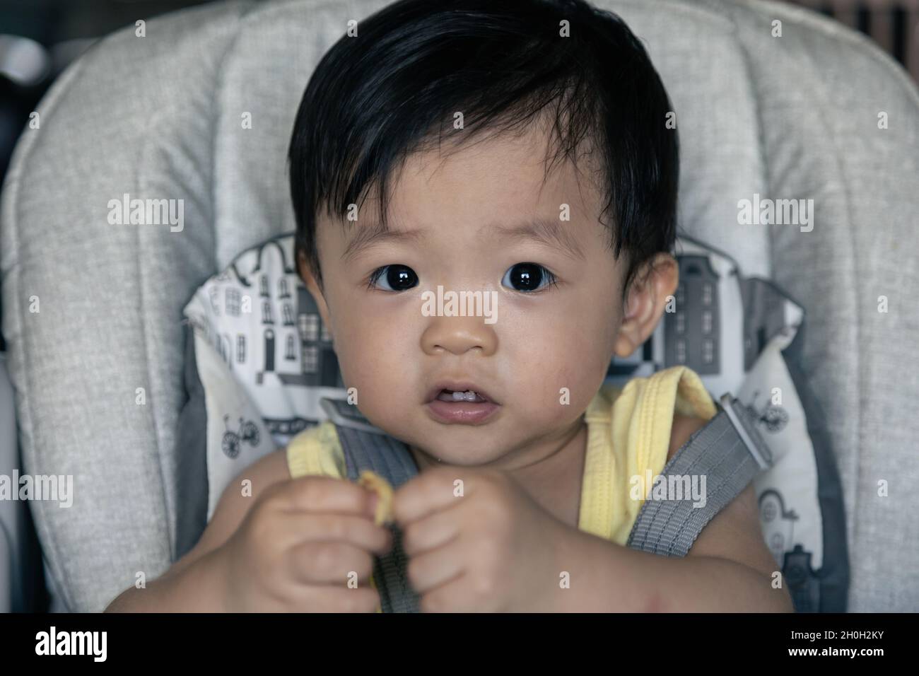 Adorable joyful and Happy 1years old Chinese baby boy having food while ...