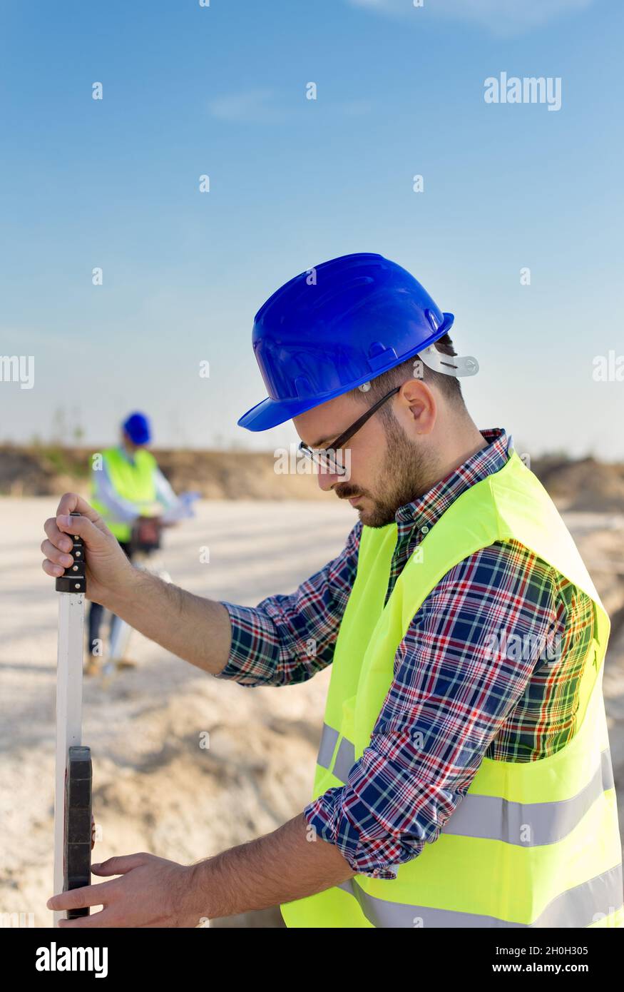 Construction worker holding laser measuring tool on building site Stock ...