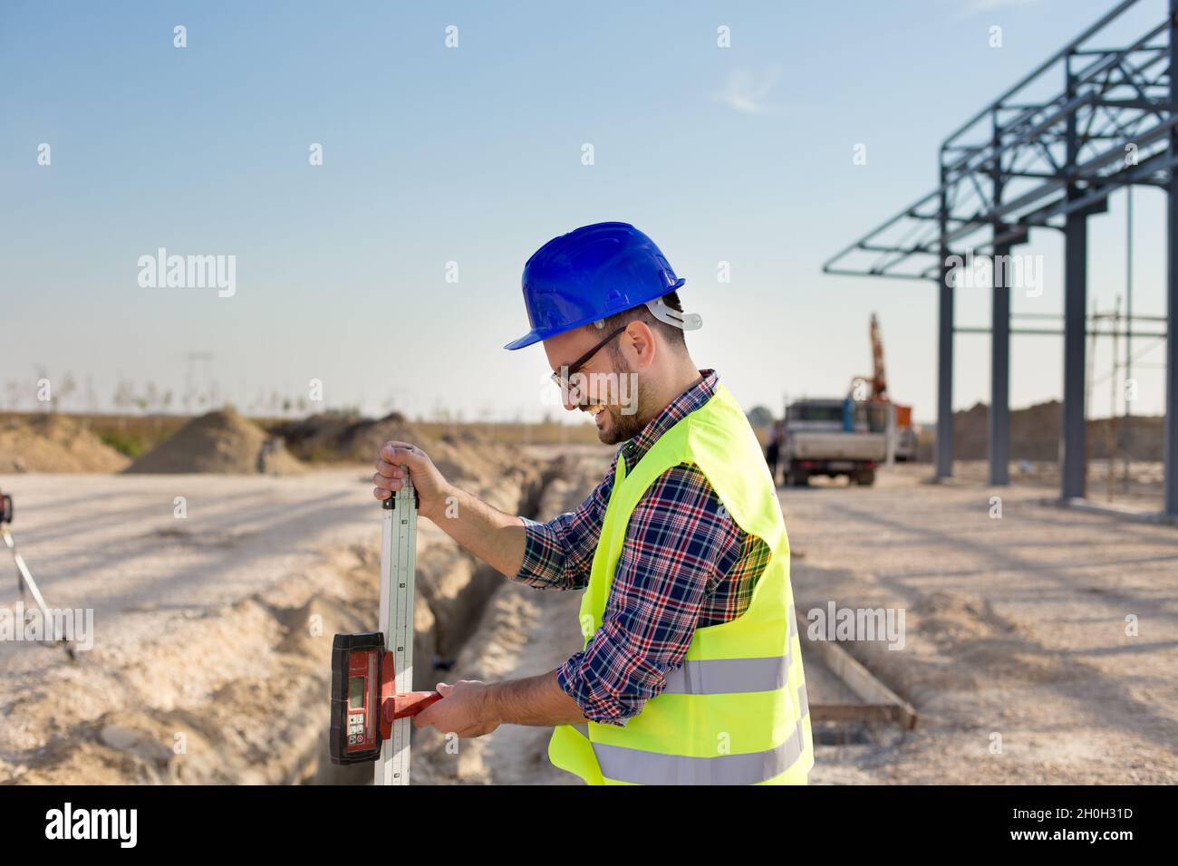 Construction worker holding laser measuring tool on building site Stock ...