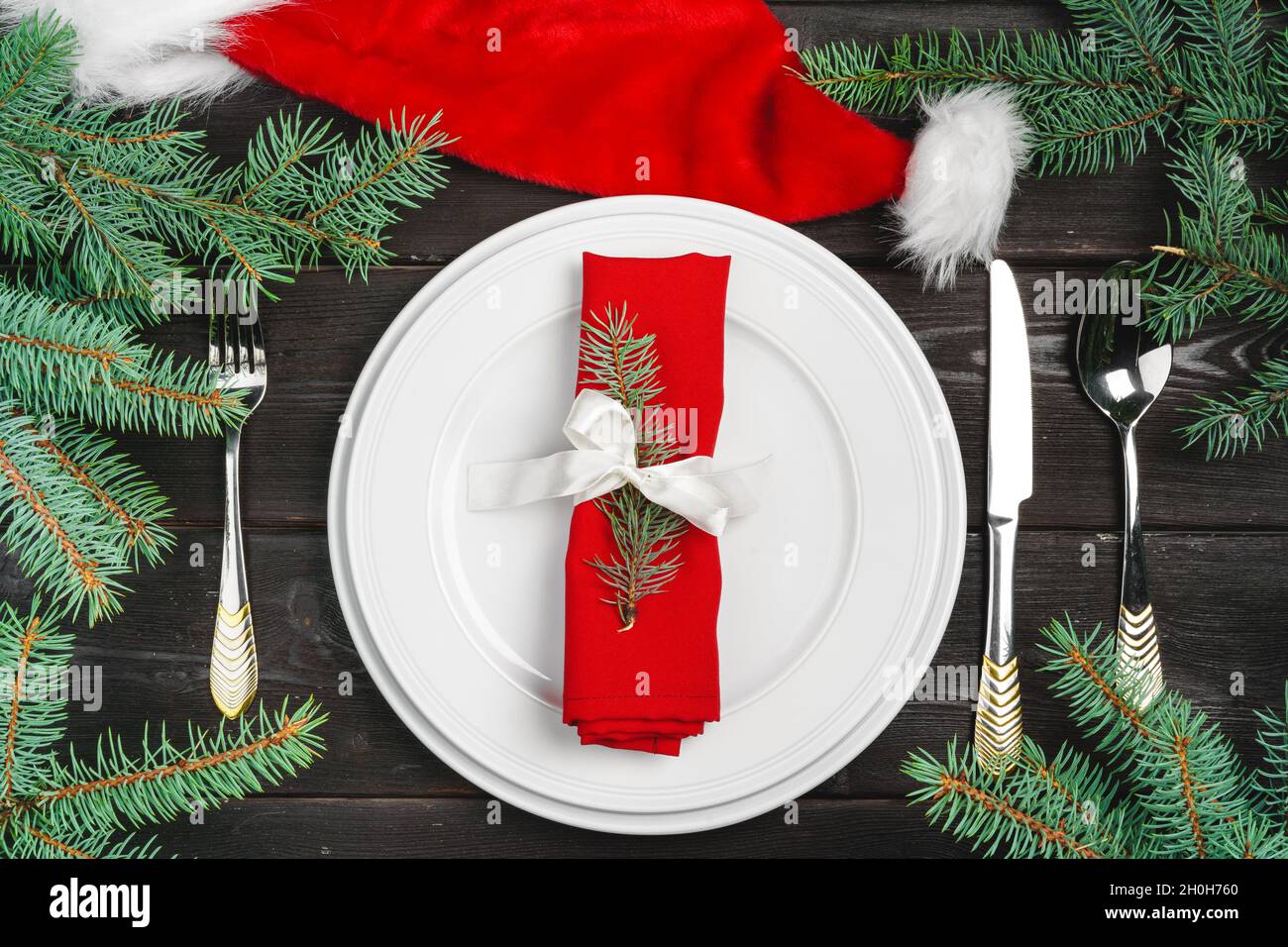Festive table setting with pine tree branches on wooden background ...