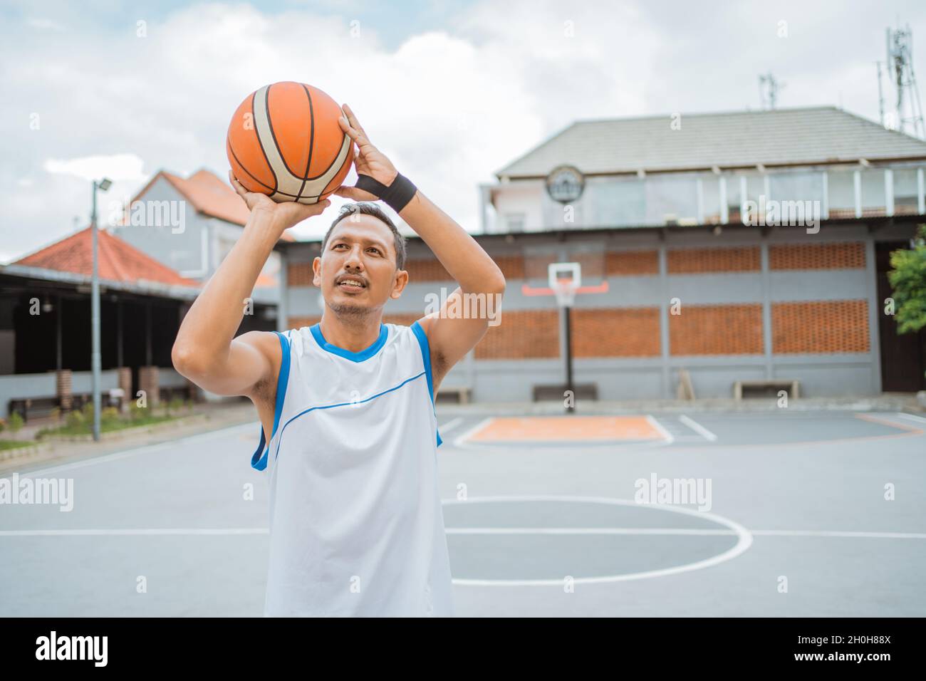 a basketball player holding a ball in a shooting position Stock Photo ...