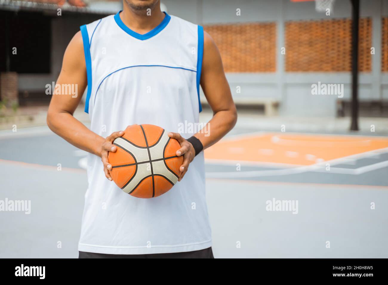 close up of male basketball player hands with basketball while standing ...