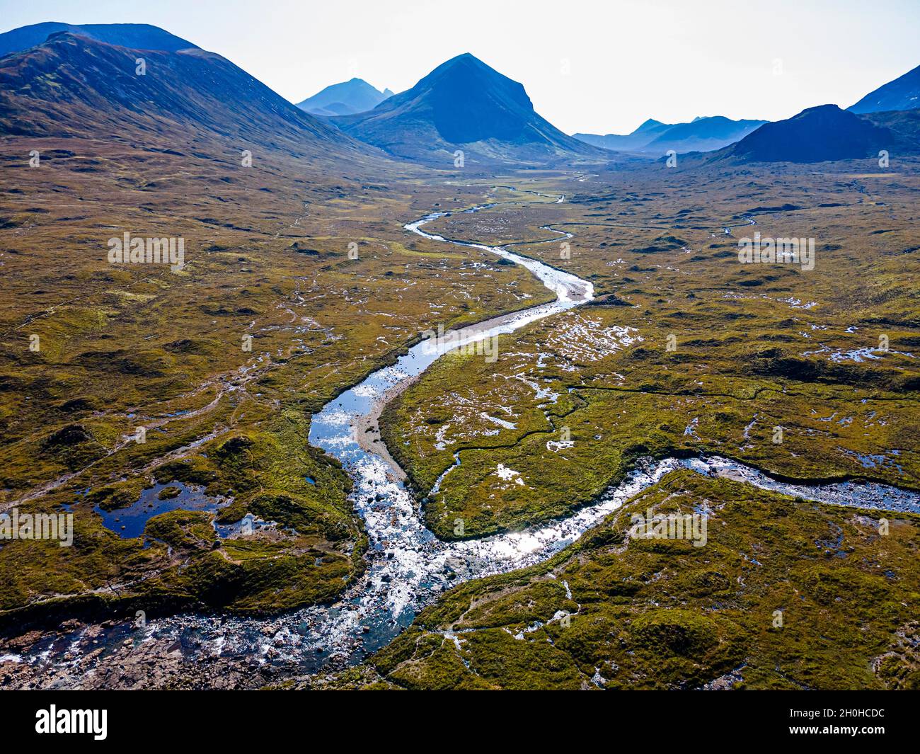 Aerial of a river sneaking through the moor of the Black Cuillin ridge ...