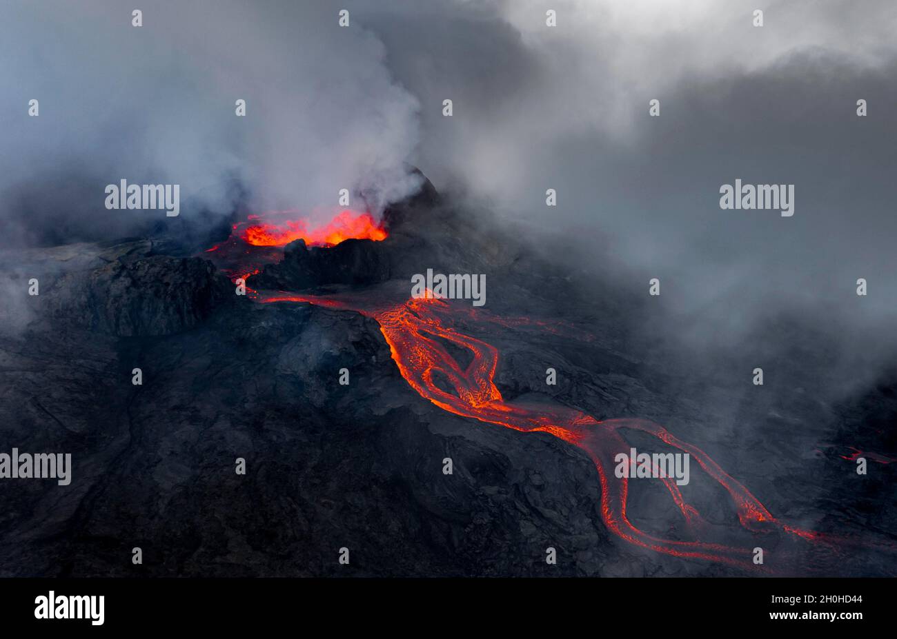Aerial view, erupting volcano with lava fountains and lava field ...