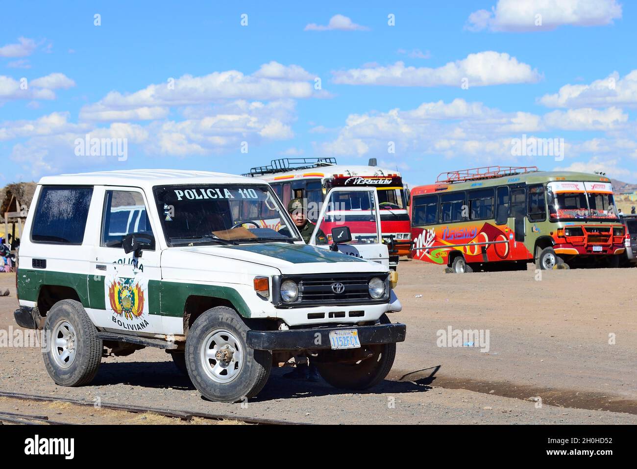 Policeman with police car in front of waiting public buses, San Pablo ...