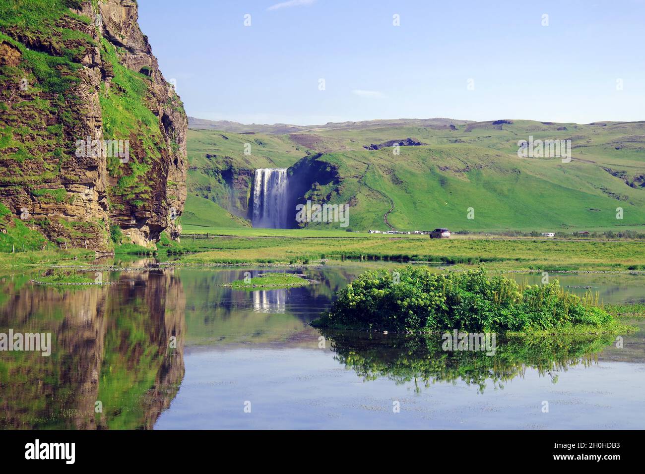 Vertically falling waterfall reflected in the water, Skogarfoss ...