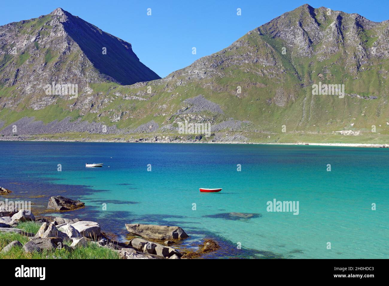 Crystal clear bay with boat, rugged mountains, Haukland, Leknes ...