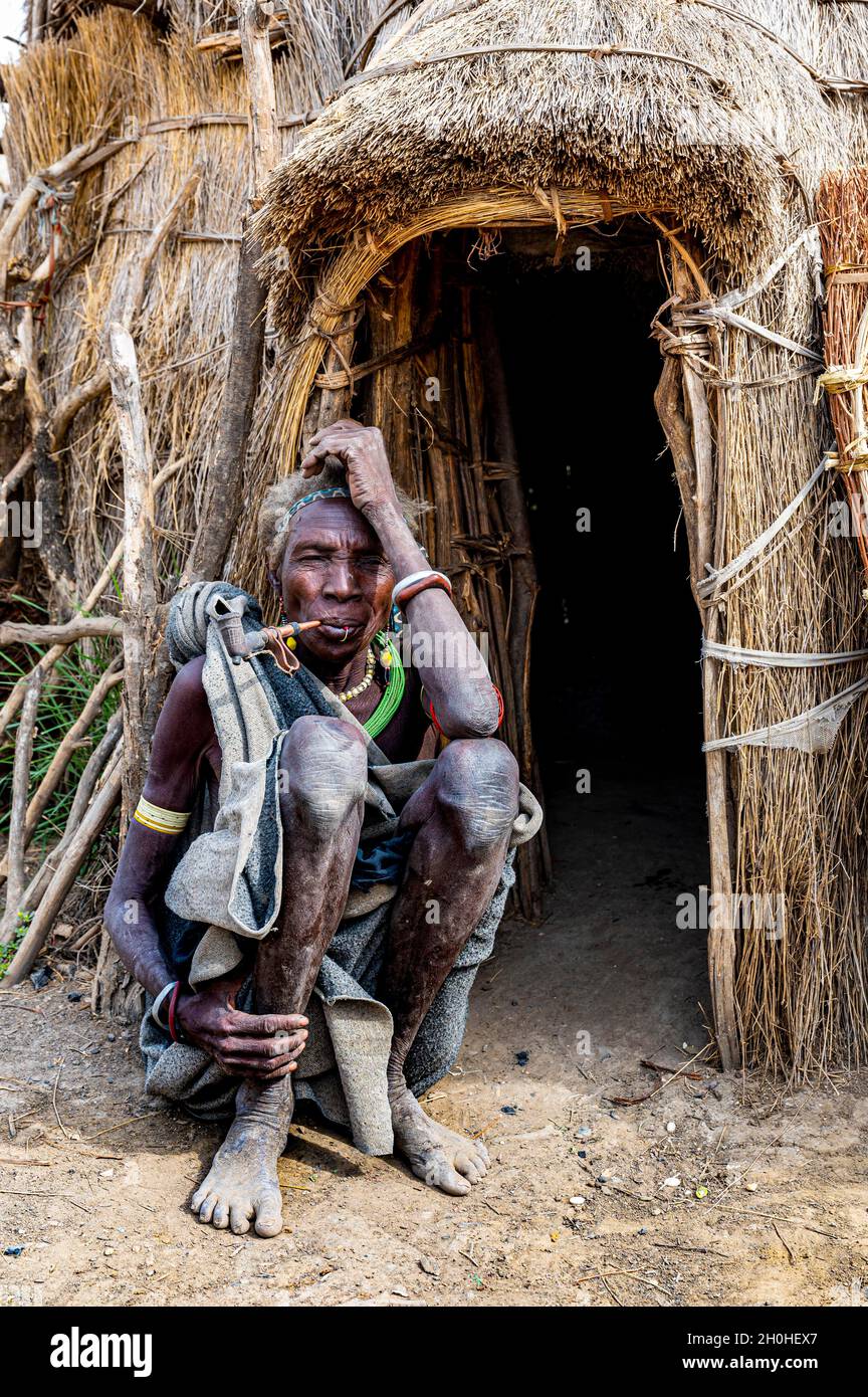 Old woman of the Jiye tribe smoking a pipe, Eastern Equatoria State ...