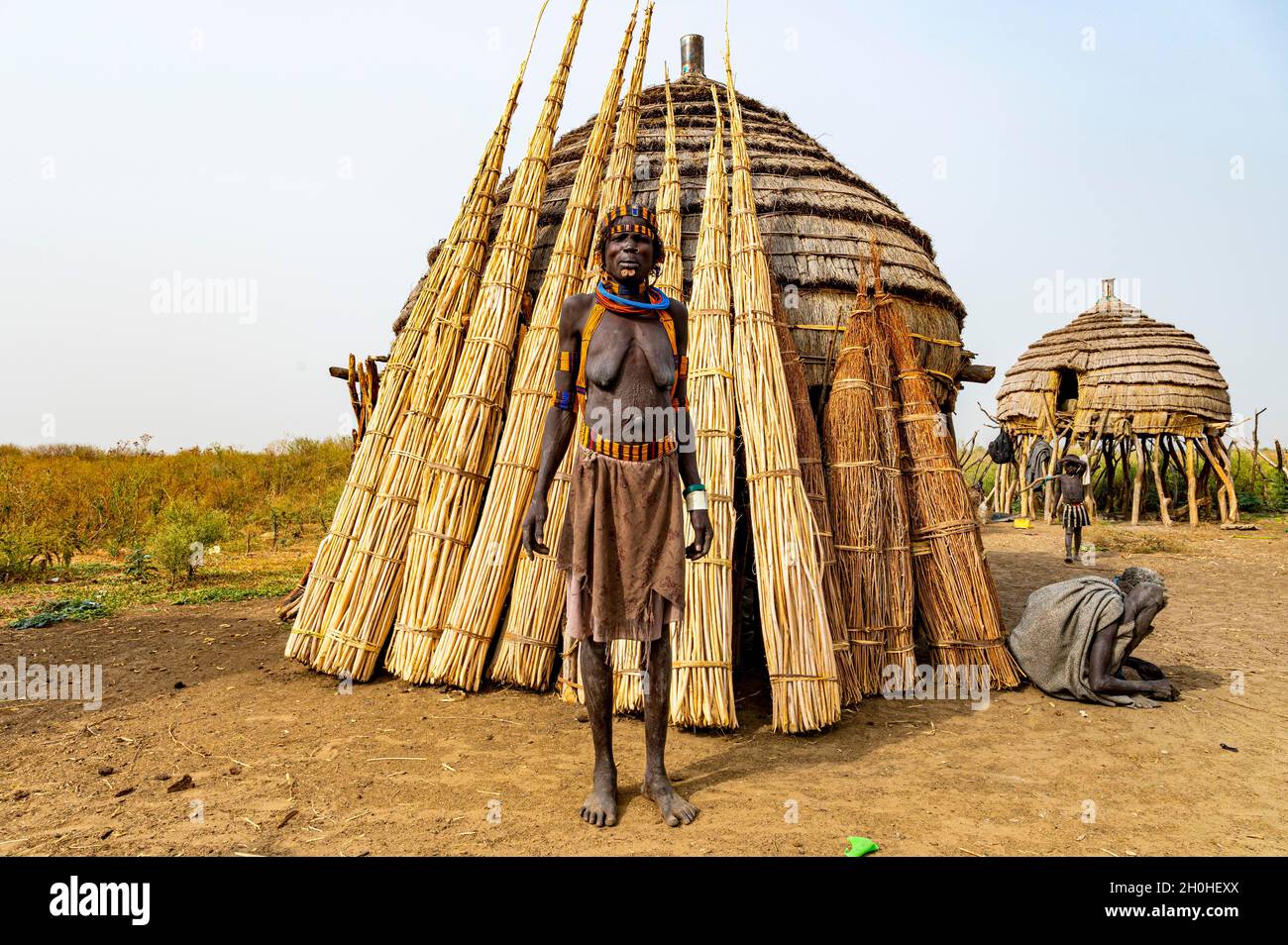 Woman before her hut with ready prepared reeds, Jiye tribe, Eastern ...