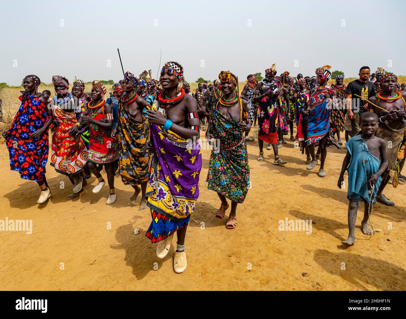 Traditional dressed women of the Jiye tribe dancing and singing ...