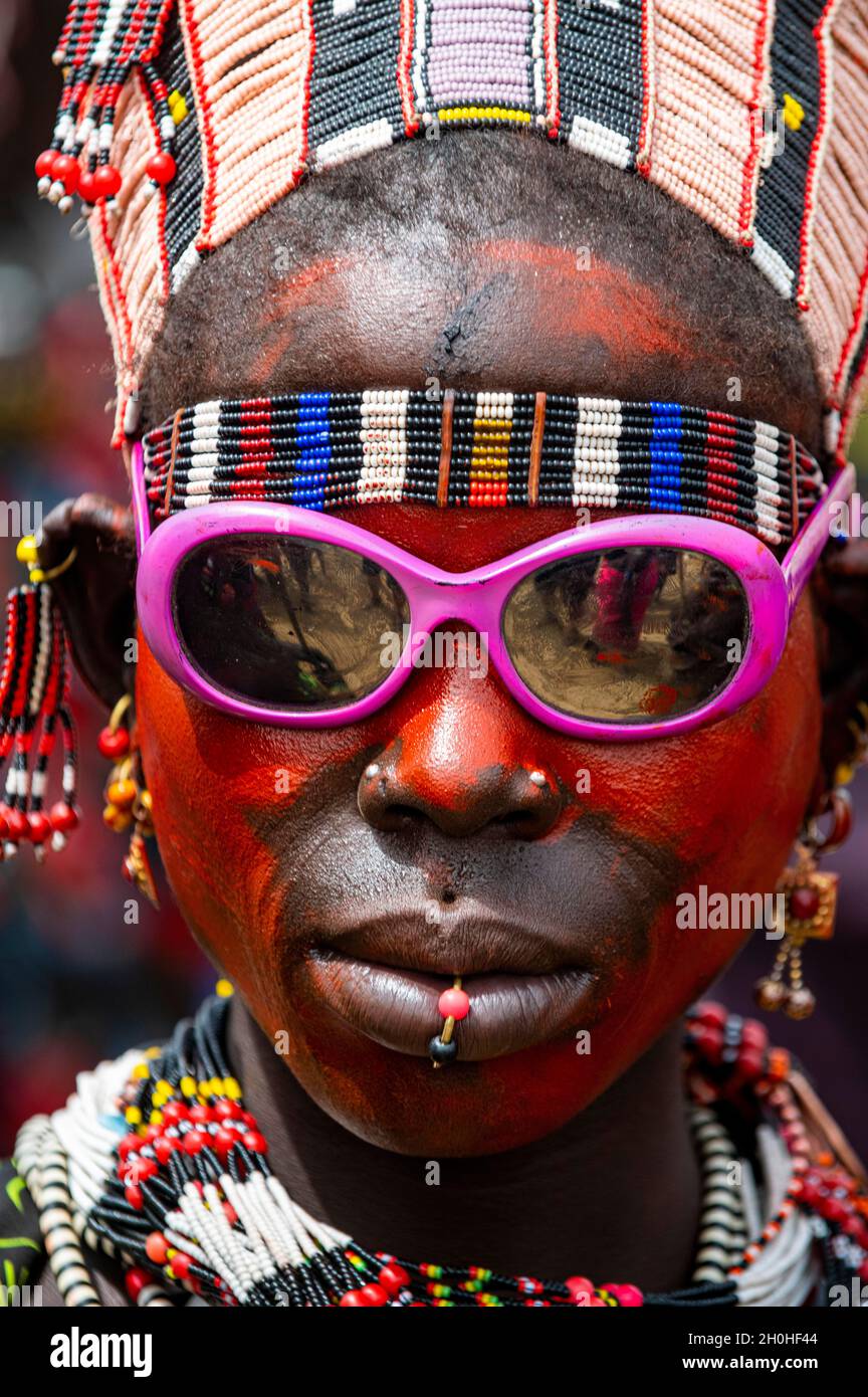 Traditional dressed woman of the Jiye tribe wearing sunglasses, Eastern ...