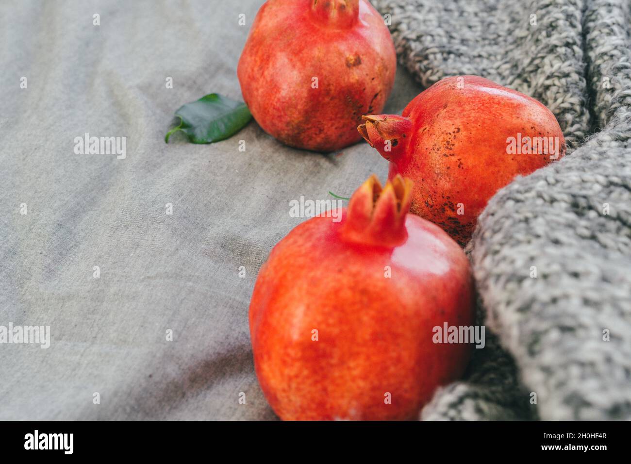 Pomegranate on a gray plaid close up Stock Photo - Alamy