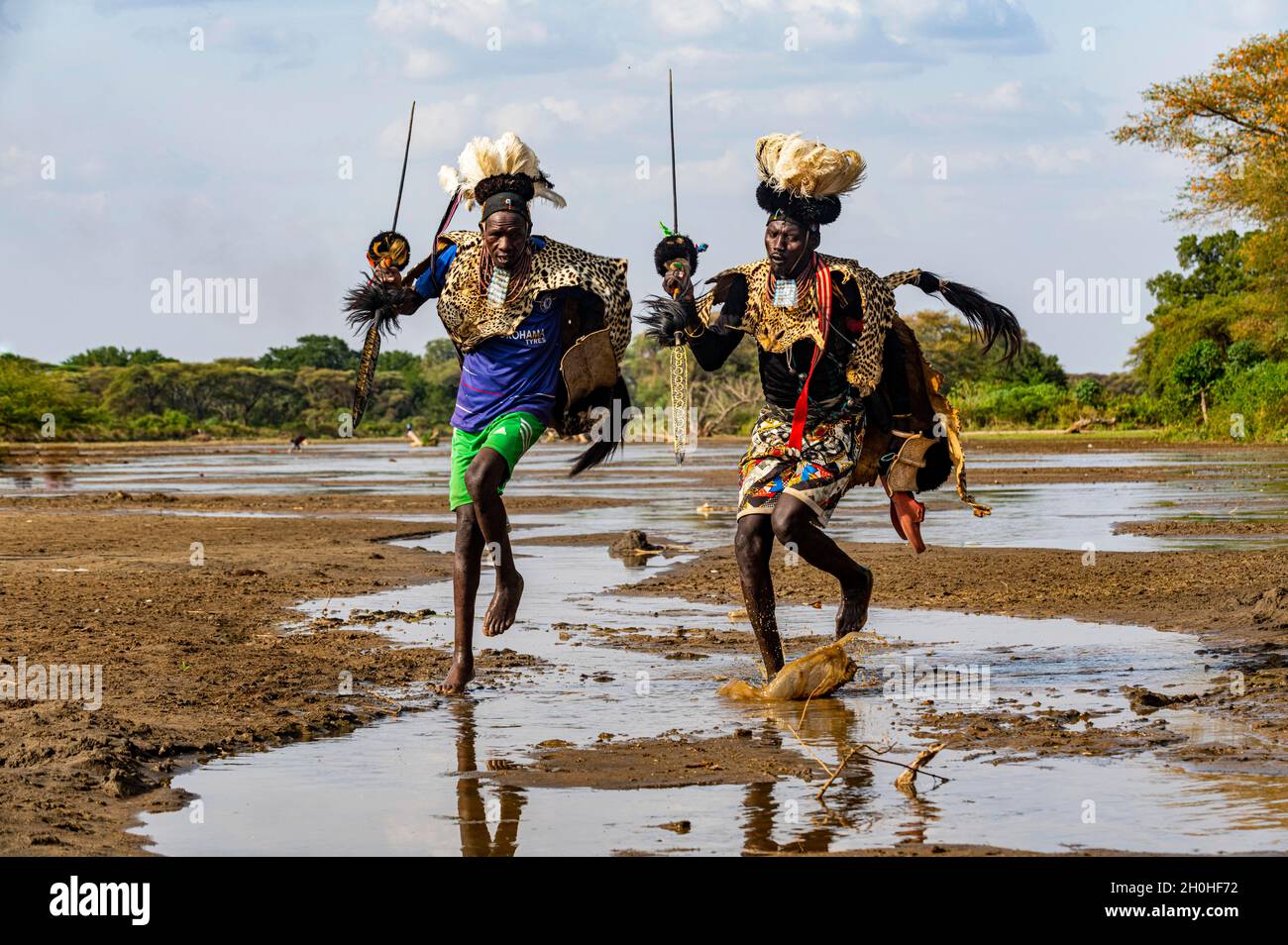 Men from the Toposa tribe posing in their traditional warrior costume ...