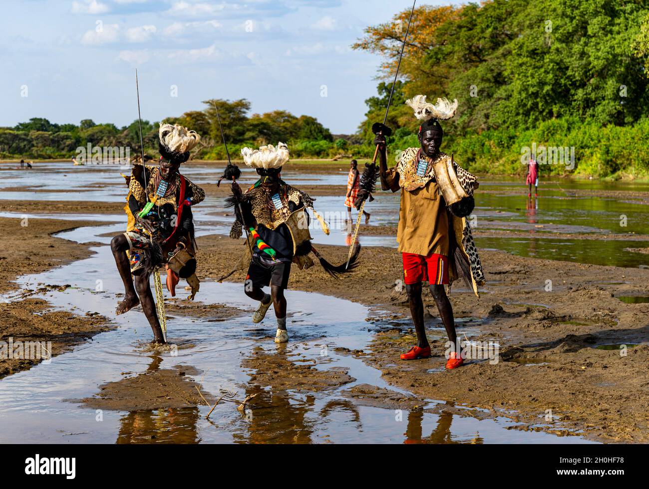 Men from the Toposa tribe posing in their traditional warrior costumes ...