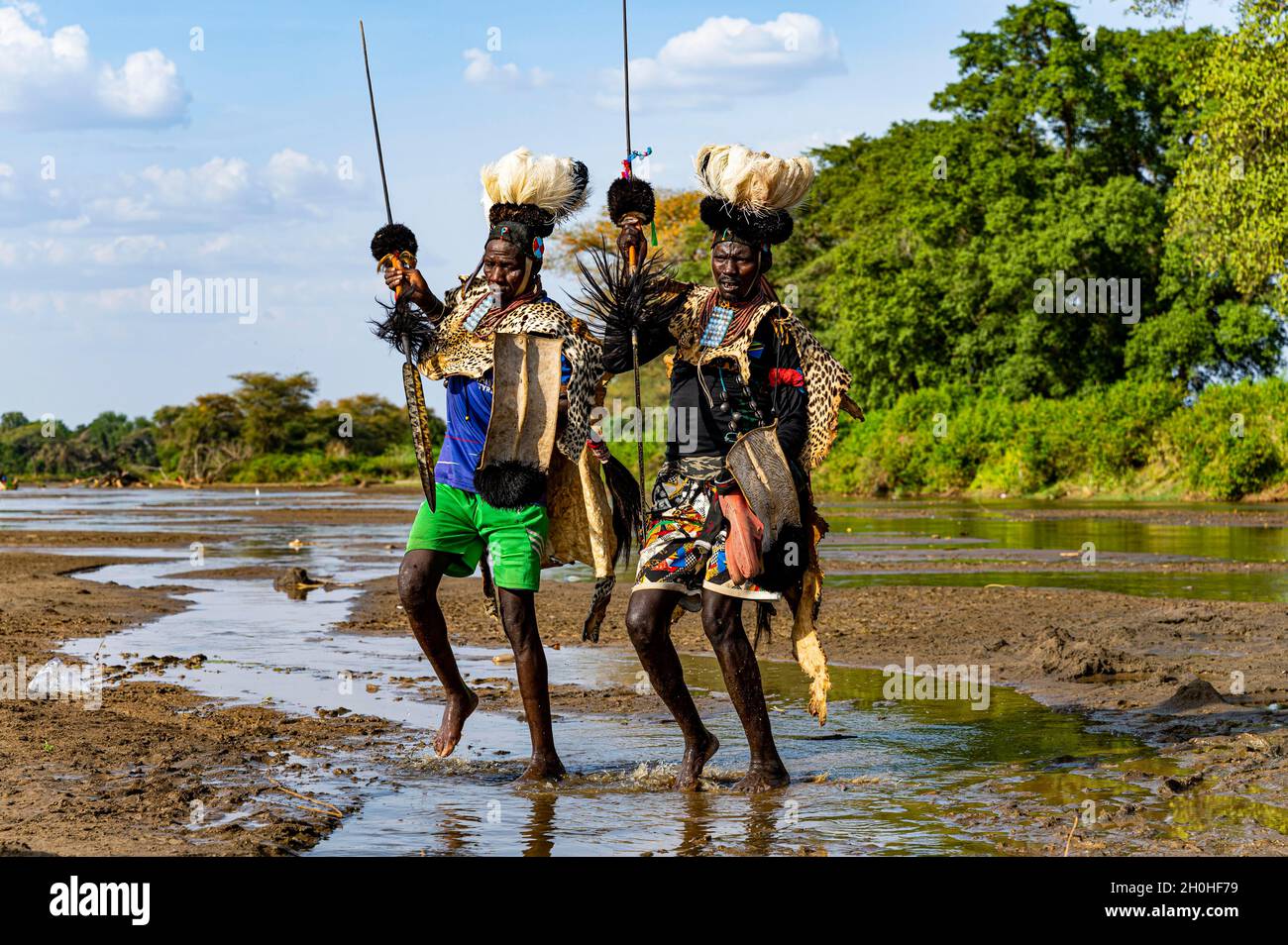 Men from the Toposa tribe posing in their traditional warrior costumes ...