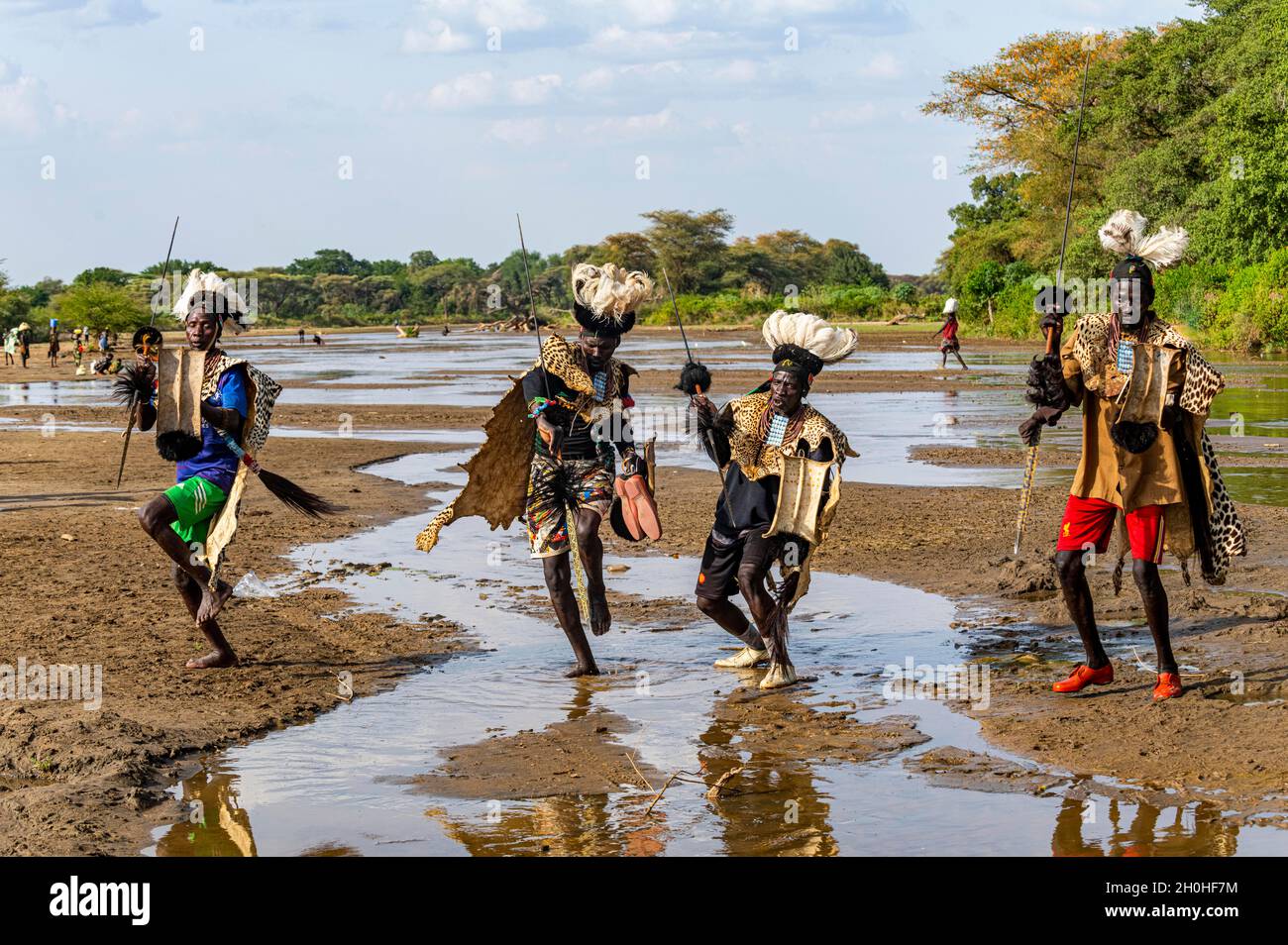 Men from the Toposa tribe posing in their traditional warrior costume ...