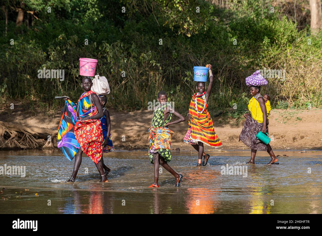 Women walking through a river bed, Toposa tribe, Eastern Equatoria ...