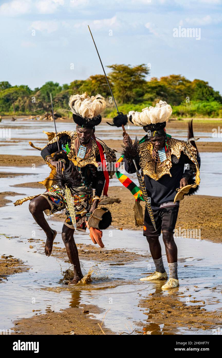 Men from the Toposa tribe posing in their traditional warrior costume ...