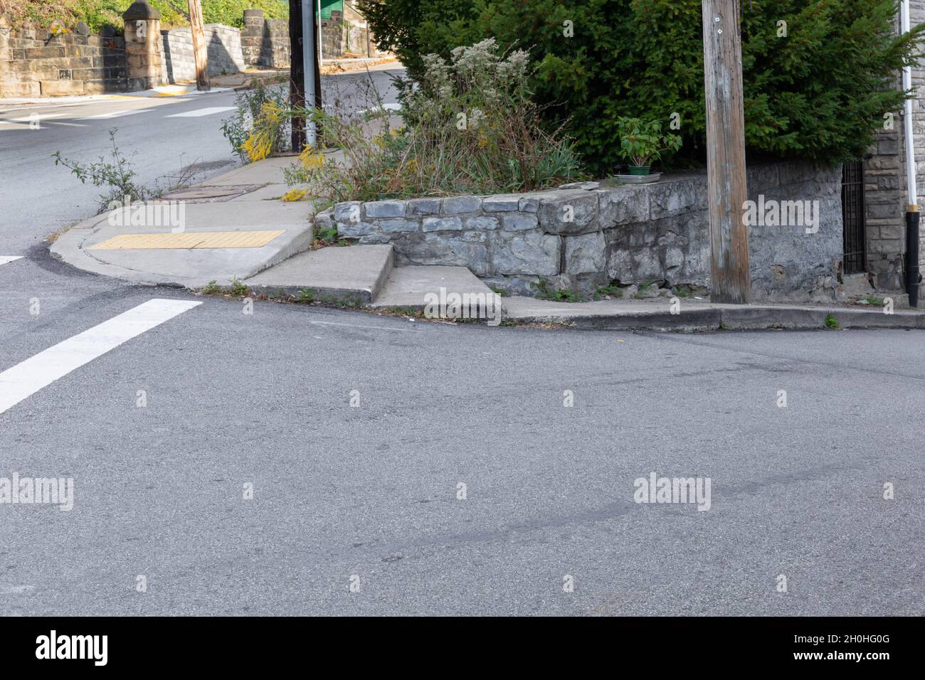 Stepped sidewalk going up around a corner, retaining wall background ...