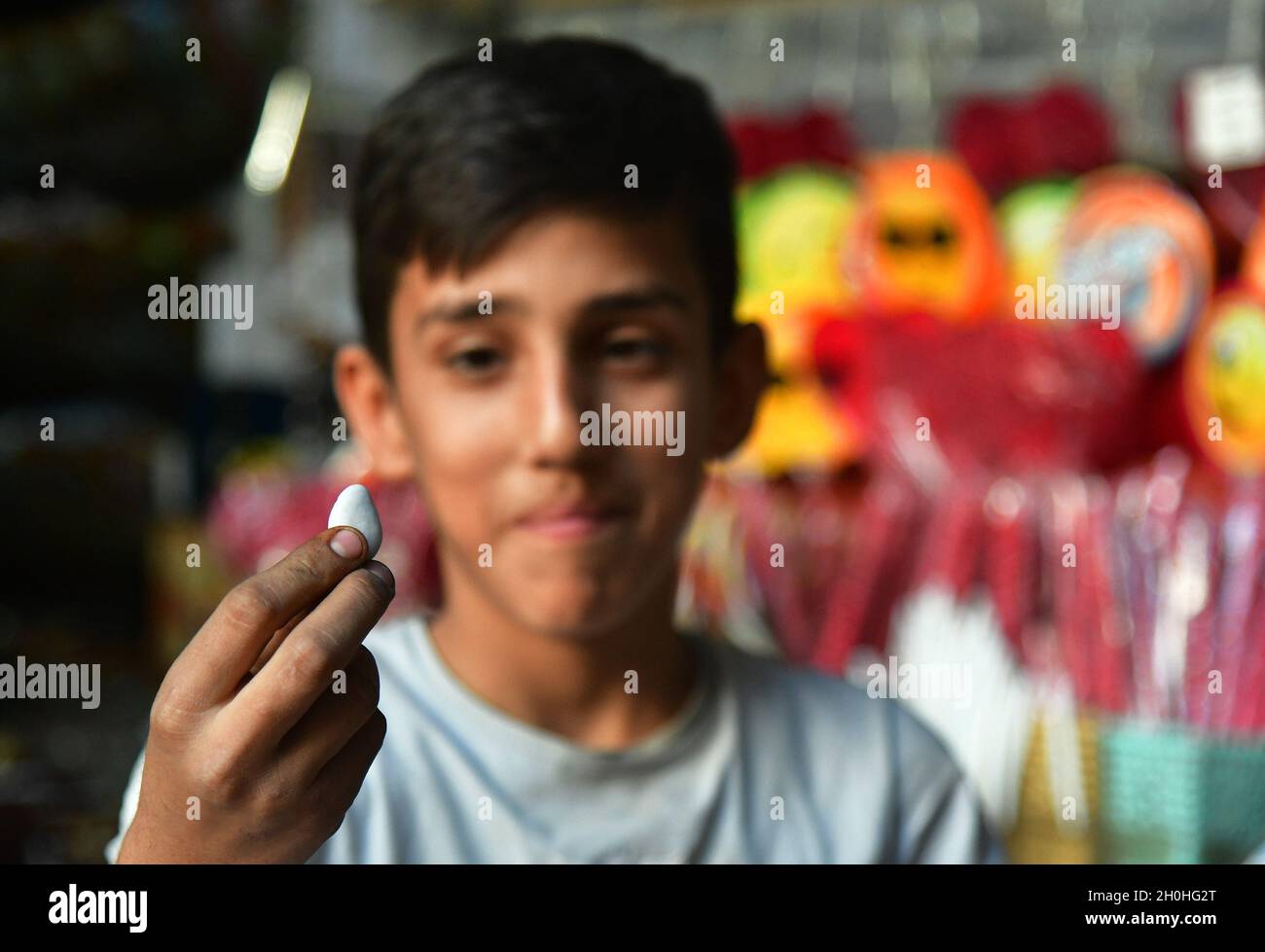 Damascus. 11th Oct, 2021. A boy holds a sweet candy in his hand in the ...