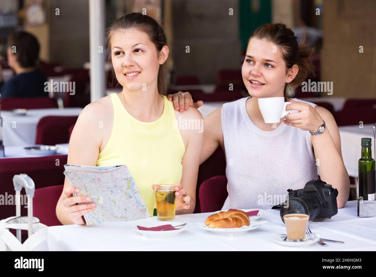 portrait of two female friends searching route on the map Stock Photo ...