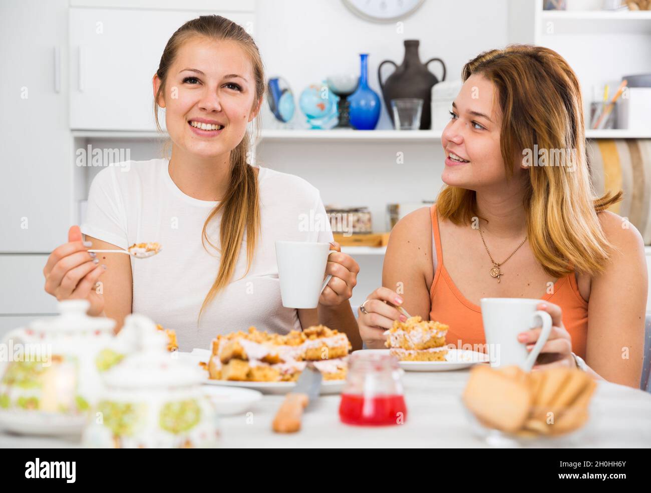 Smiling friends drinking tea with pie Stock Photo - Alamy