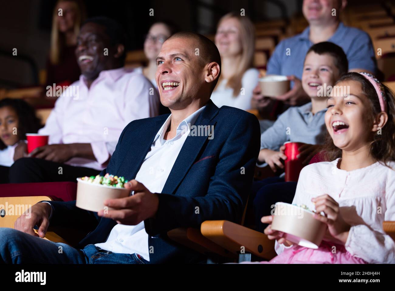 Cheerful man laughing while watching comedy movie in cinema Stock Photo ...