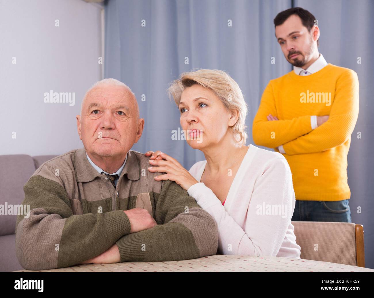 Man seriously talking with family Stock Photo - Alamy
