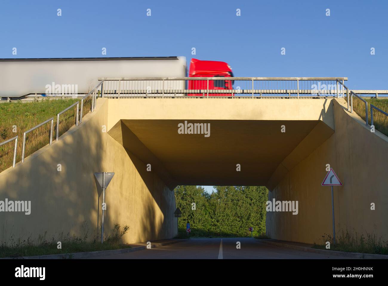 Large transport or haulage lorry passing overhead on the bridge over an ...