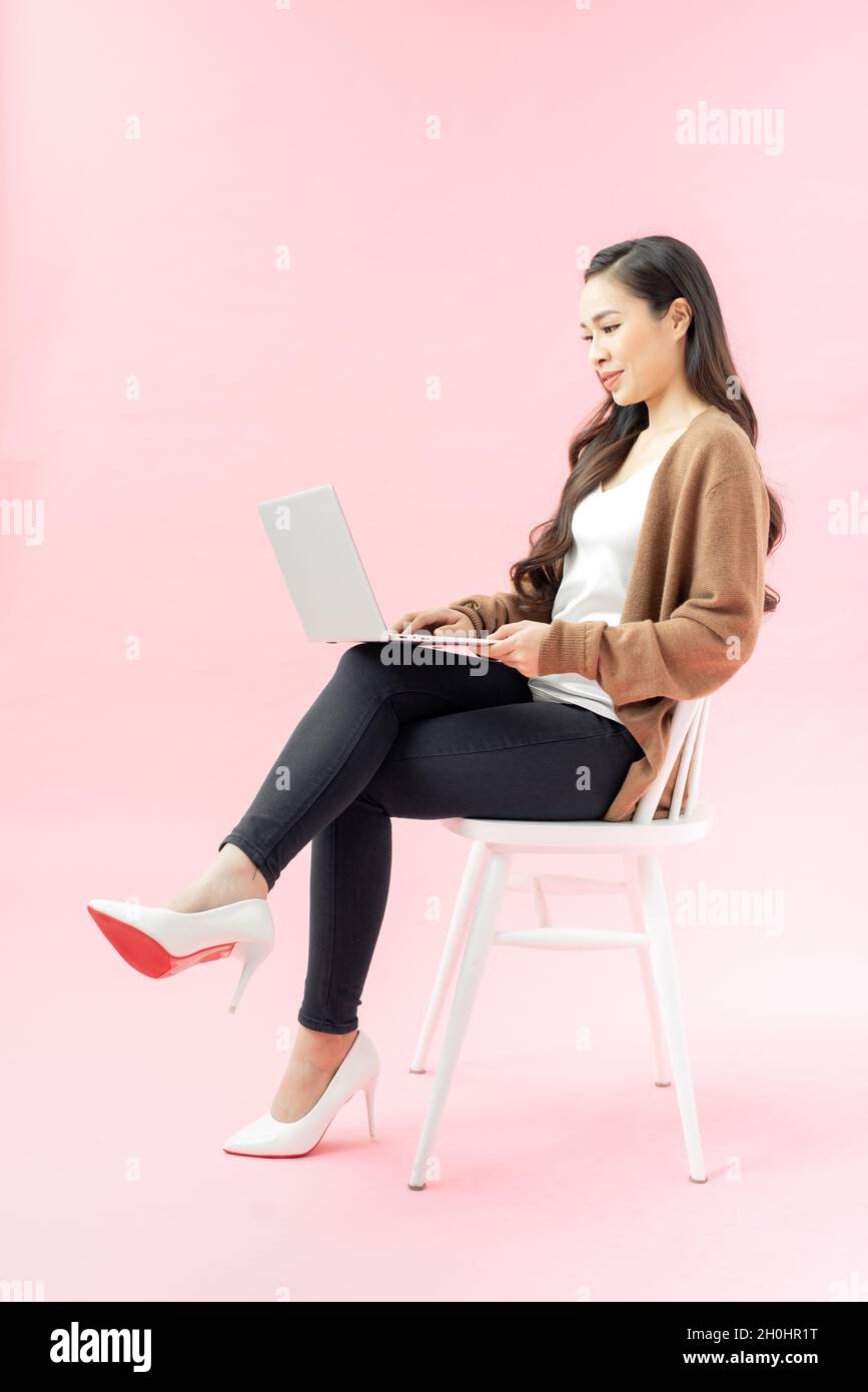 Smart beautiful young girl using laptop pc computer isolated on blue ...