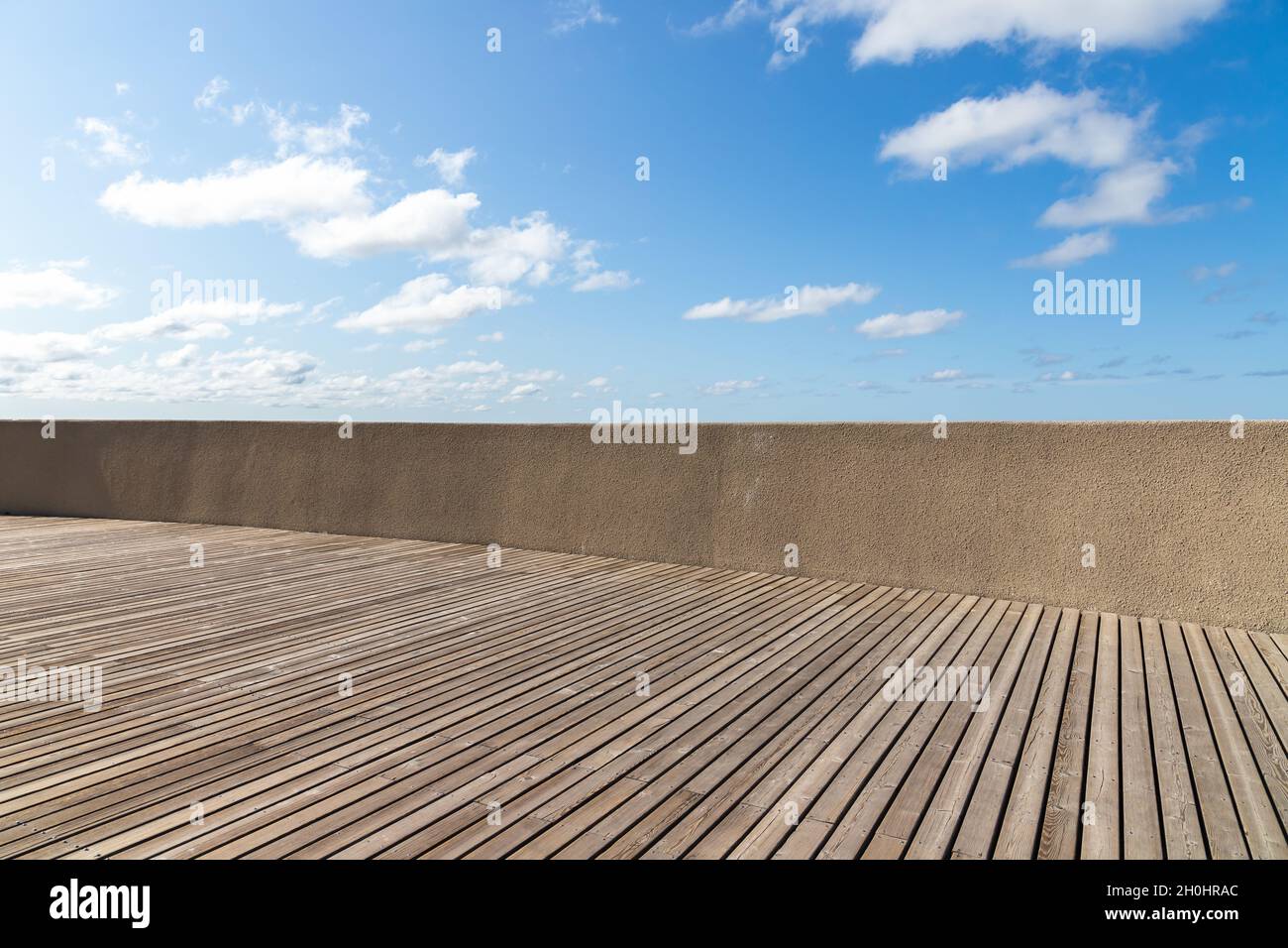Empty promenade with wooden floor and concrete railing at the sea coast ...