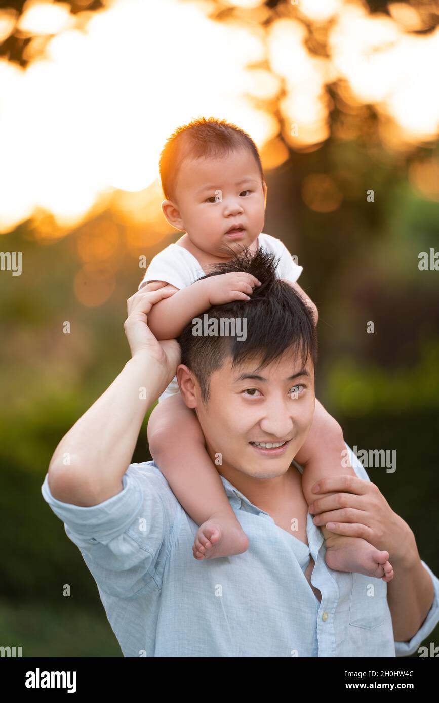 Young father raising his baby to play Stock Photo - Alamy