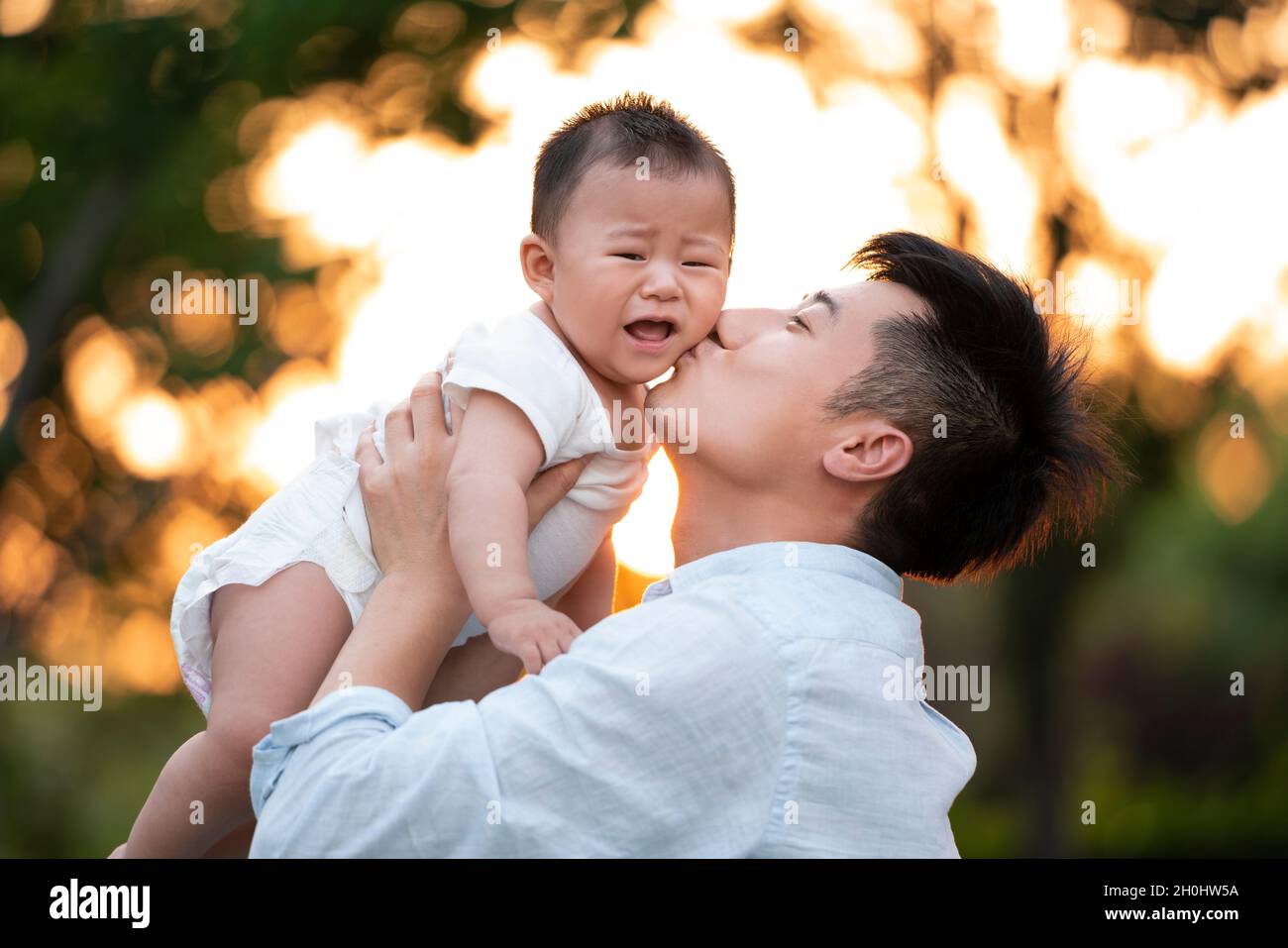 Young father raising his baby to play Stock Photo - Alamy