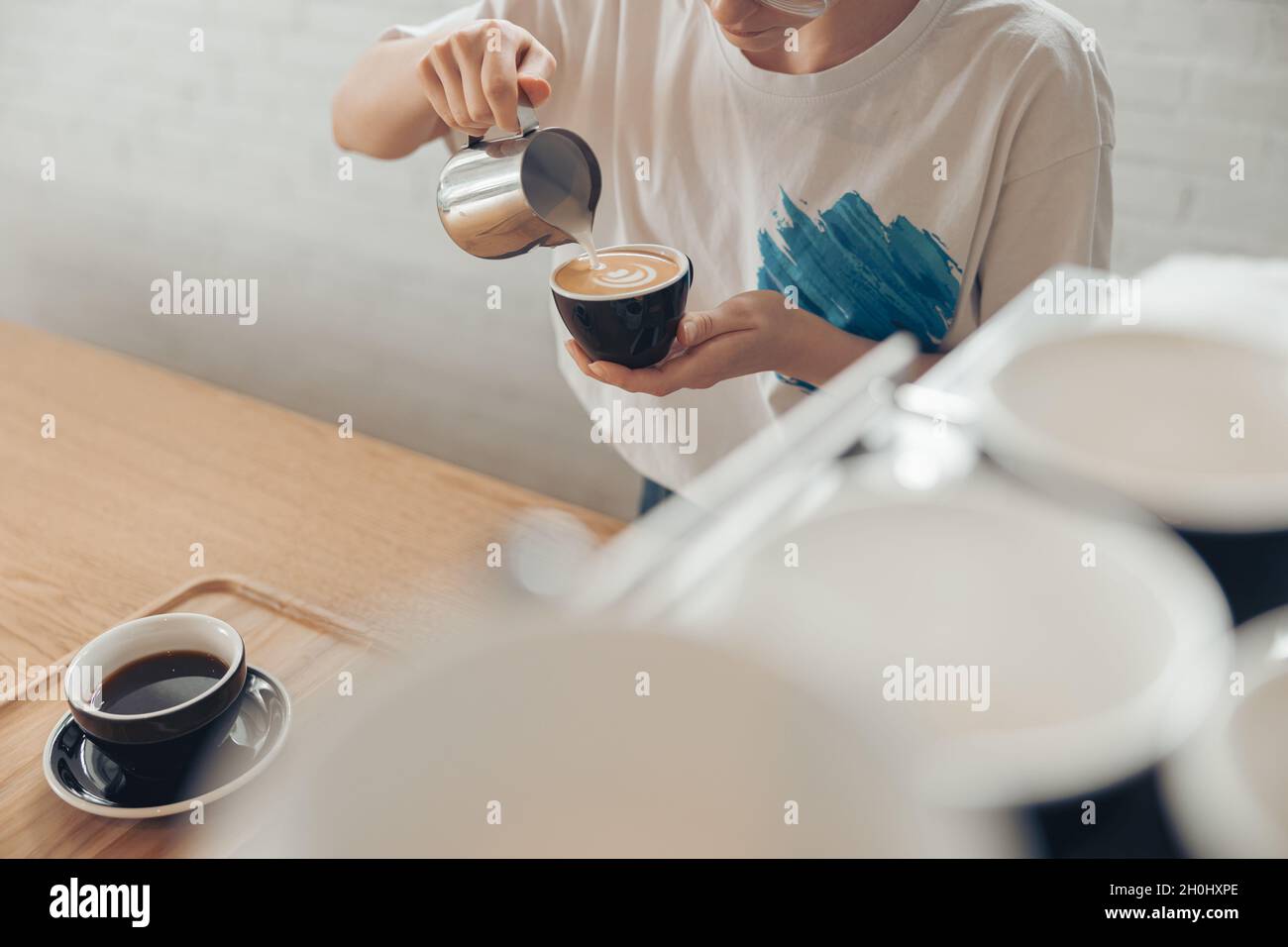 Young woman making latte art in cafeteria Stock Photo - Alamy