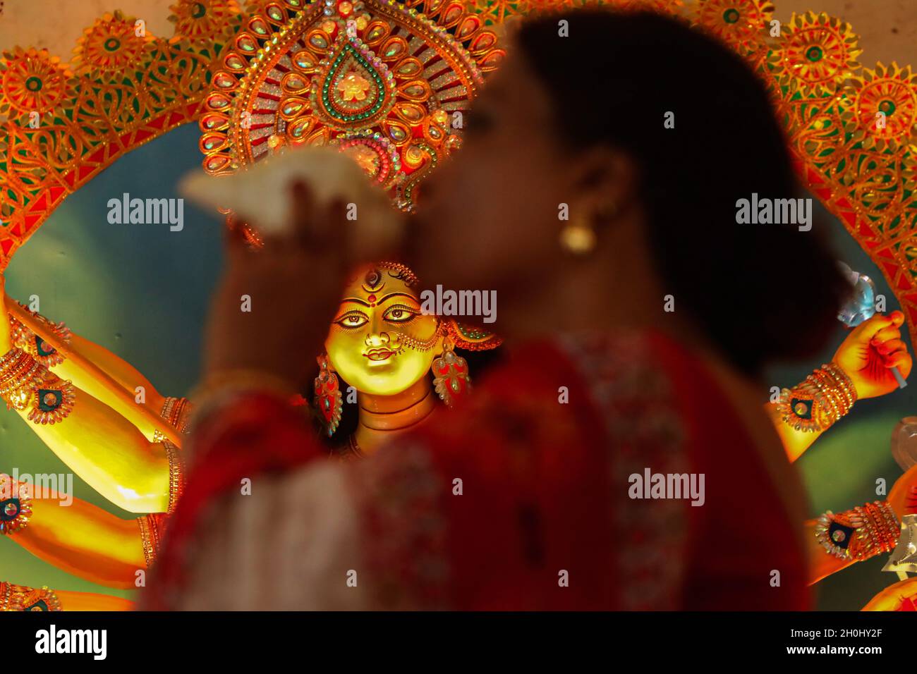Hindu Devotee seen blowing conch shells amid the idol of Goddess Durga ...