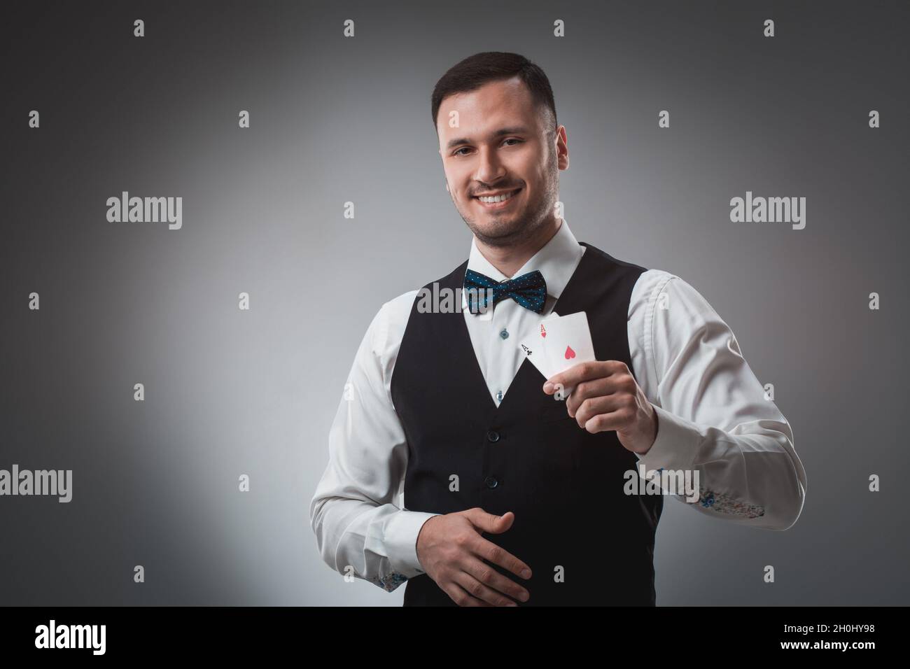 Handsome confident man holding cards looking at camera Stock Photo - Alamy
