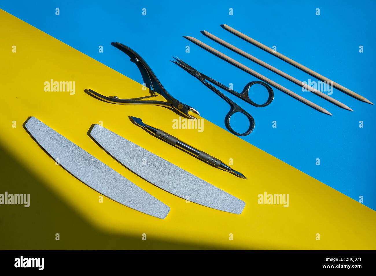 Set of disinfected manicure or pedicure tools on yellow and blue ...
